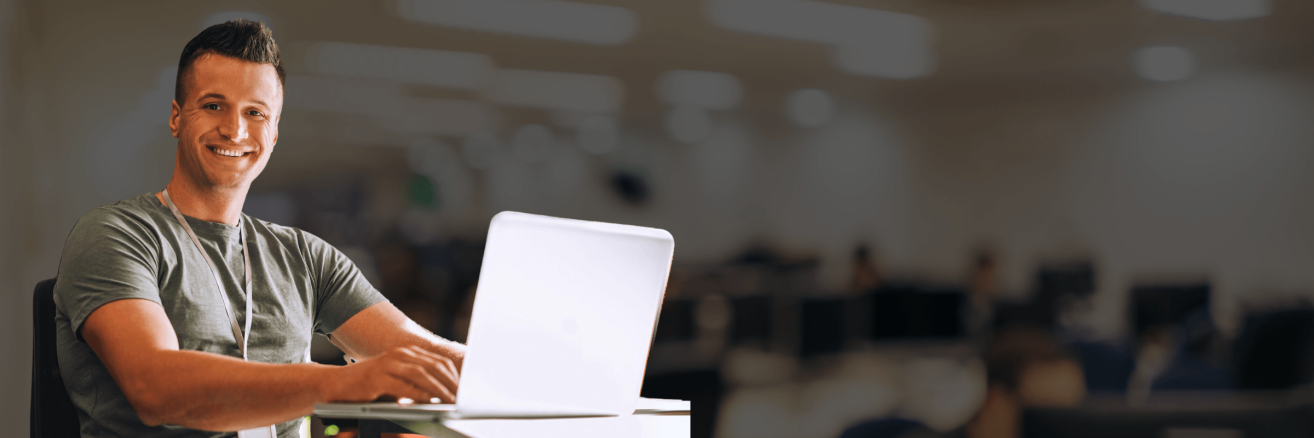 Smiling Electrical Estimator working on his laptop - Vision InfoSoft